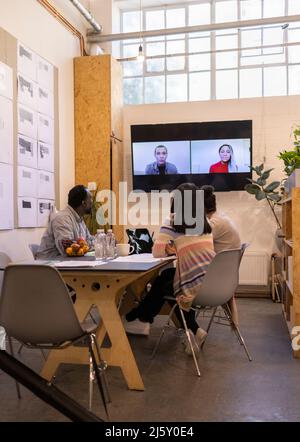 Creative business people video conferencing at laptop in conference ...