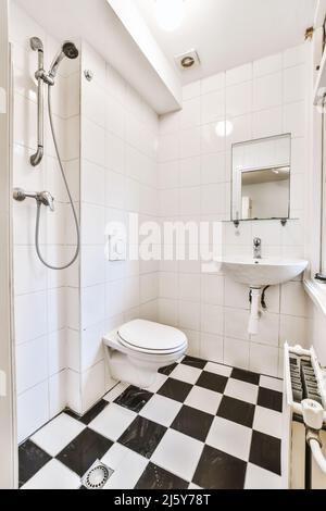 White ceramic toilet and shower placed in light stylish bathroom at ...