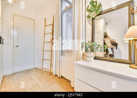 Chest of drawers near wall with mirror Stock Photo - Alamy