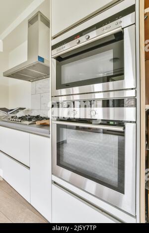 Contemporary built in ovens placed near counter in modern kitchen with ...