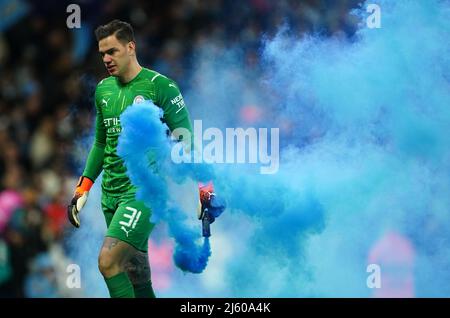 Manchester City goalkeeper Ederson clears a flare of the pitch after ...