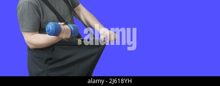 The man pulls down his pants at the waist and lifts the dumbbell, the ...