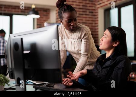 Multiethnic cyber security team members in agency office writing cloud database processing ...