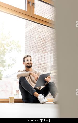 man with tablet pc sitting on sofa at home Stock Photo - Alamy