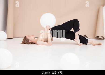 Young woman with balloon practicing yoga by brown backdrop Stock Photo ...