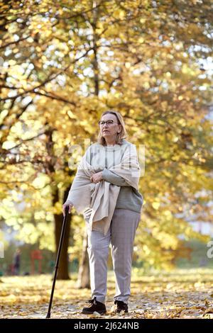 Senior woman with walking stick Stock Photo - Alamy