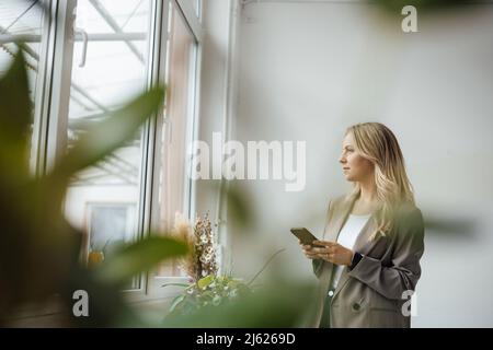 Businesswoman use of mobile phone out of office Stock Photo - Alamy