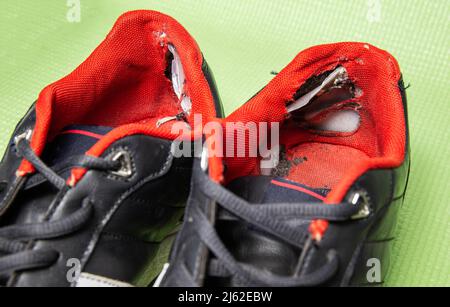 A ripped backdrop in sporty multicolored sneakers. Poor quality shoes ...