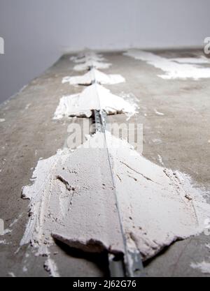 Leveling the walls with a plaster mixture and metal beacons. Plastering ...