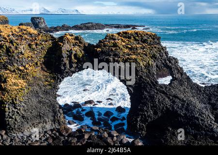 Photograph of the volcanic rock bridge at the Gatklettur Cliff walk ...