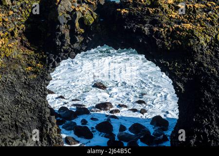 Photograph of the volcanic rock bridge at the Gatklettur Cliff walk ...
