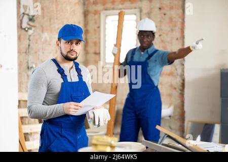 Portrait of frustrated builder holding dismissal letter Stock Photo - Alamy