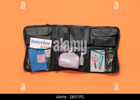 Travel organizer with cosmetics, stationery and bottle of water on ...