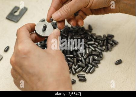 Woman checks small hunter bullets with caliber over table Stock Photo ...