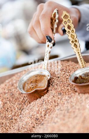 A Turkish coffee cooking in the traditional pot on the oven Stock Photo ...