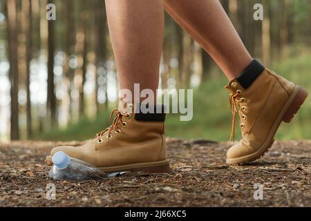 Yellow boots and plastic bottle in a forest Stock Photo - Alamy