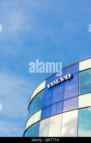 Volvo brand logo on bright blue sky background located on its sale ...