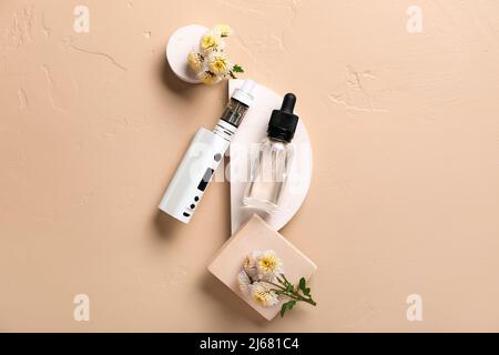 Modern vape mod, oil and flowers on beige background Stock Photo - Alamy