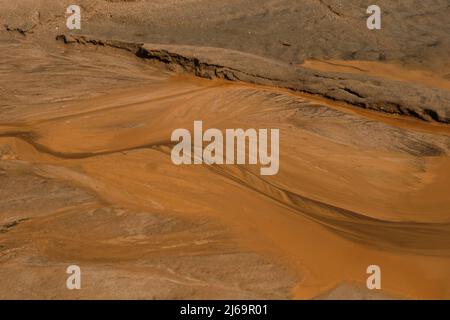 Wet sand and beautiful streaks from the water top view. Natural sand ...