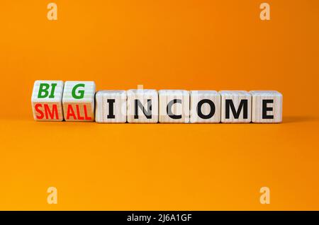 Big or small income symbol. Turned wooden cubes and changed concept ...