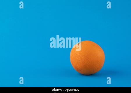 Whole navel orange on solid blue background Stock Photo - Alamy