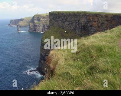 colorful ocean views, green grassy rocks, rocks and blue water. The ...