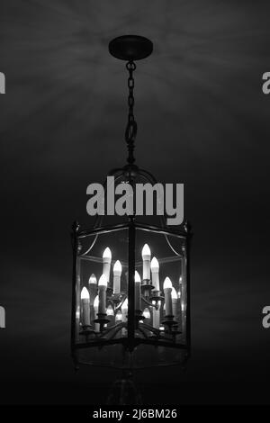 A traditional colonial chandelier hanging from the ceiling creating the ...