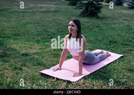 Woman performing cobra pose Stock Photo - Alamy