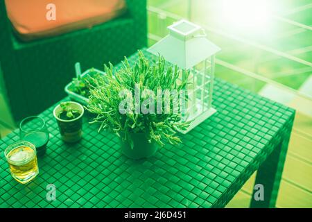 Modern house terrace with lantern, glasses and plant on the table. High ...