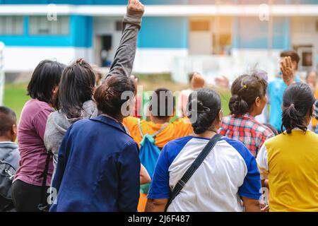 Back view of Moms watch and cheering their sons playing football in ...