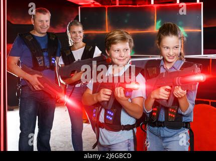 Portrait of positive man with laser gun having fun with her friends on ...