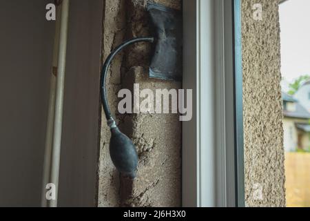 Person using inflatable air wedge or shim to hold the window frame in ...