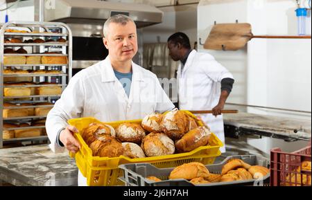Baker sorts finished products at the bakery Stock Photo - Alamy