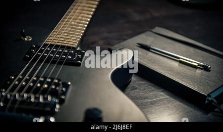 Close-up, electric guitar and notepad, concept of musical creativity ...