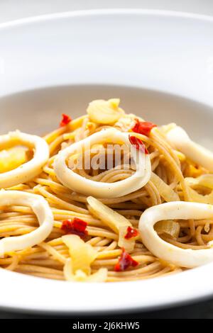 spaghetti with calamari, chilli pepper and onion Stock Photo - Alamy