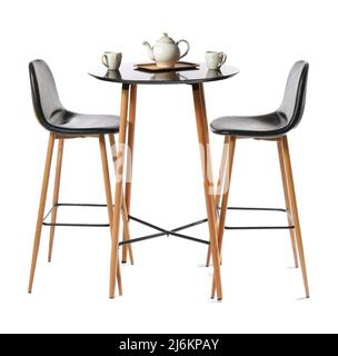 Wooden chairs at table with black teapot and bowls in black modern ...