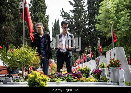 Man standing over grave at cemetery Stock Photo - Alamy