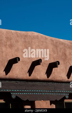 large wooden beams protruding from concrete exterior wall of adobe home ...