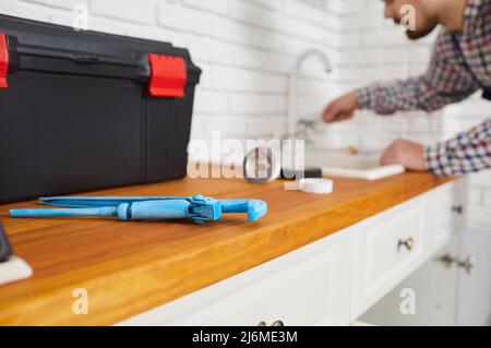Plumber repairing tap at kitchen Stock Photo - Alamy