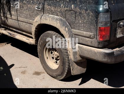 SUV covered in mud. The wheels and body of the car are splattered with ...