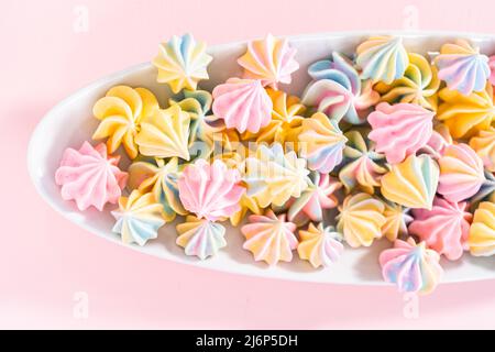 Multicolored unicorn meringue cookies on a white serving plate Stock ...