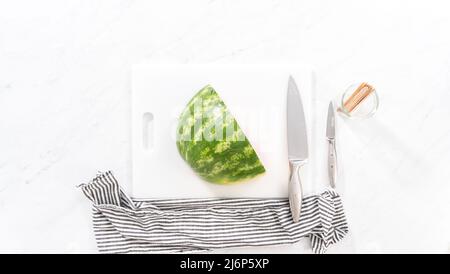 Flat lay. Slicing riped red watermelon to prepare chili lime watermelon ...