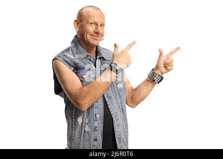 Bald rocker man in a denim vest posing and gesturing rock and roll sign ...