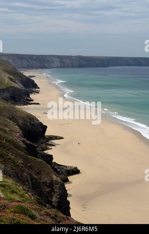 St. Agnes Bay, Cornwall - 2 July 202: Sandy beach with lone walkers and ...