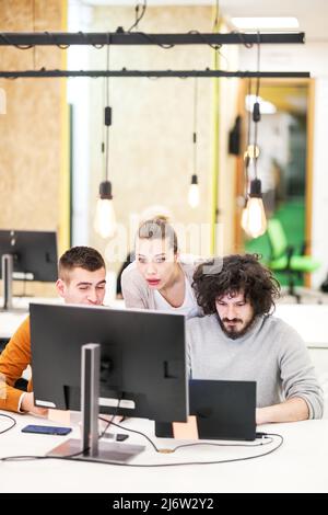 Three caucasian colleagues cheering for job well done in a modern ...