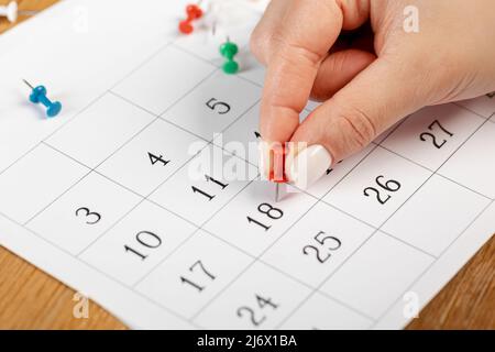 red Hand pin stuck on the day of the month in the calendar, business ...