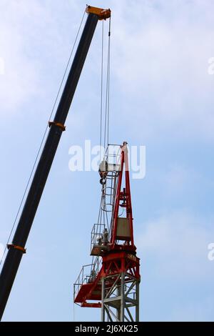 Mobile crane lifting a concrete counterweight into position for a tower ...