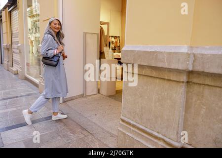 Busy mature lady taking stroll through city Stock Photo - Alamy