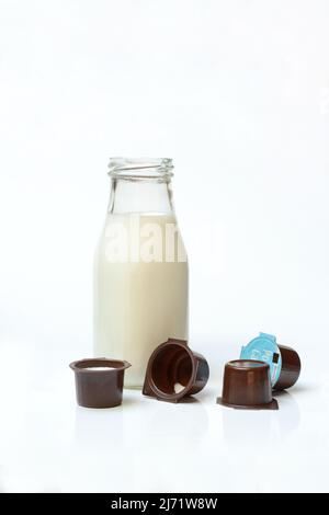 A bottle of milk and milk in portion pack, white background Stock Photo ...
