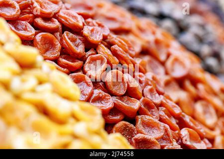 Piles of dried apricots of different varieties on counter at market ...